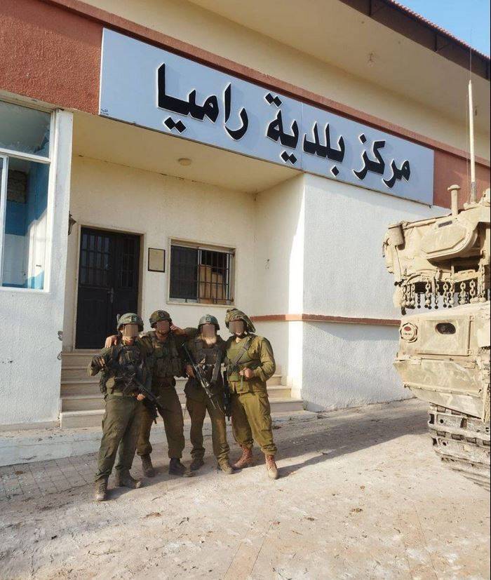 Des soldats israéliens posent devant la municipalité de Ramiyé, au ...